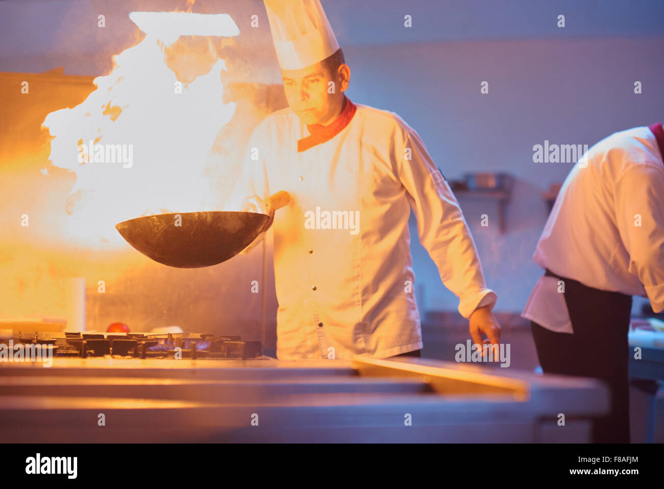 chef in hotel kitchen prepare vegetable food with fire Stock Photo - Alamy