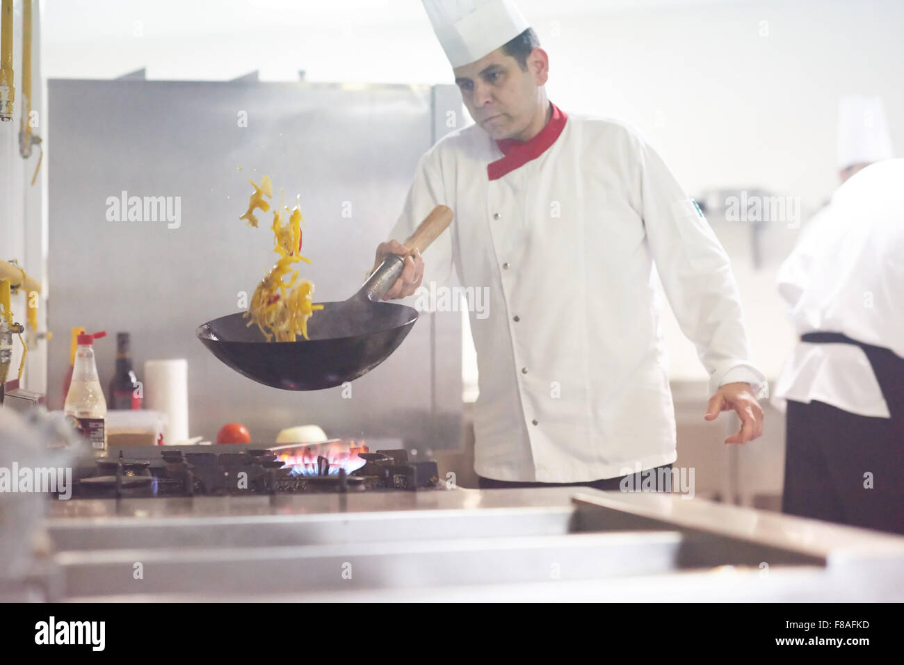 chef in hotel kitchen prepare vegetable food with fire Stock Photo - Alamy
