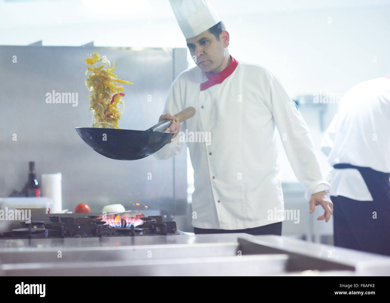 chef in hotel kitchen prepare vegetable food with fire Stock Photo - Alamy