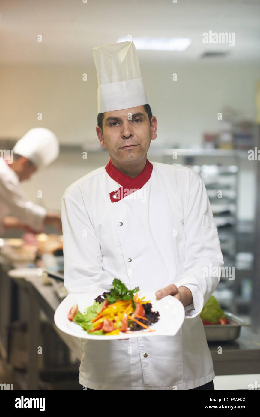 chef in hotel kitchen preparing and decorating food, delicious ...