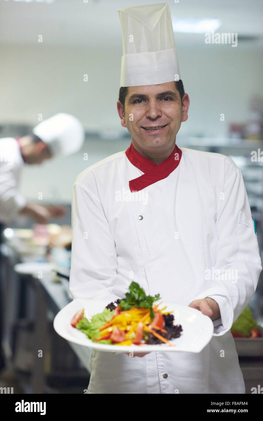 chef in hotel kitchen preparing and decorating food, delicious ...