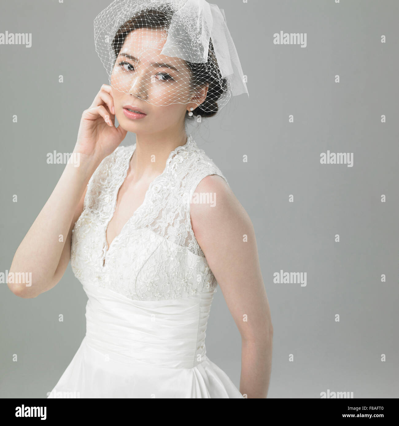Korean bride touching her cheek Stock Photo - Alamy