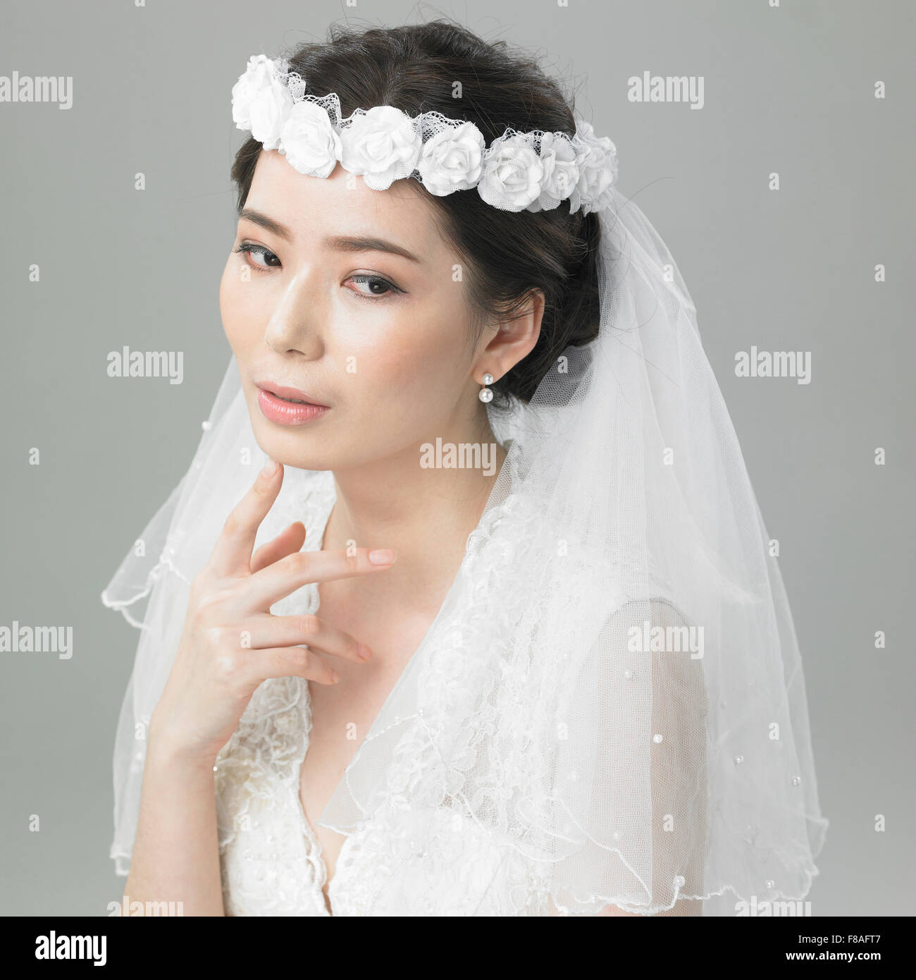 Korean bride in wedding dress with wedding veil touching her chin Stock ...