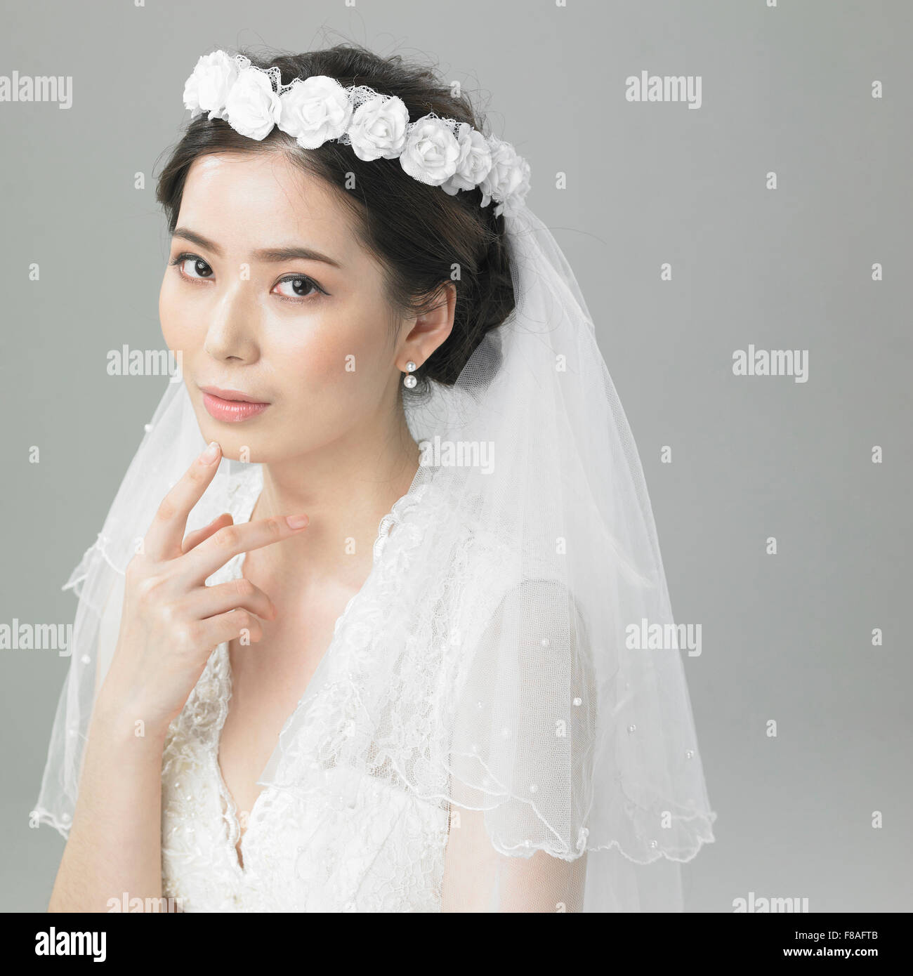 Korean bride in wedding dress with wedding veil touching her chin Stock ...
