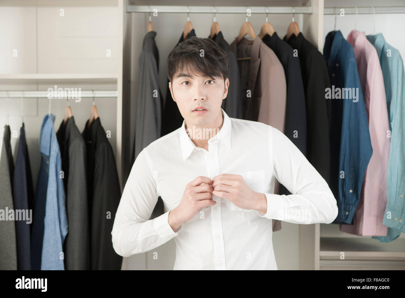 Man buttoning up his shirt Stock Photo - Alamy