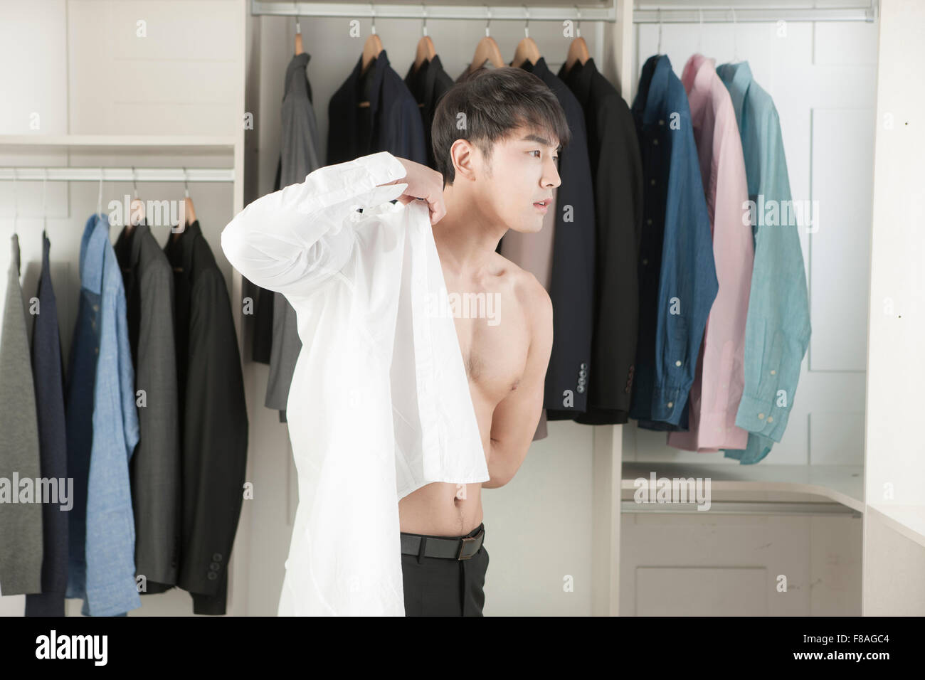 Man putting his shirt on Stock Photo - Alamy