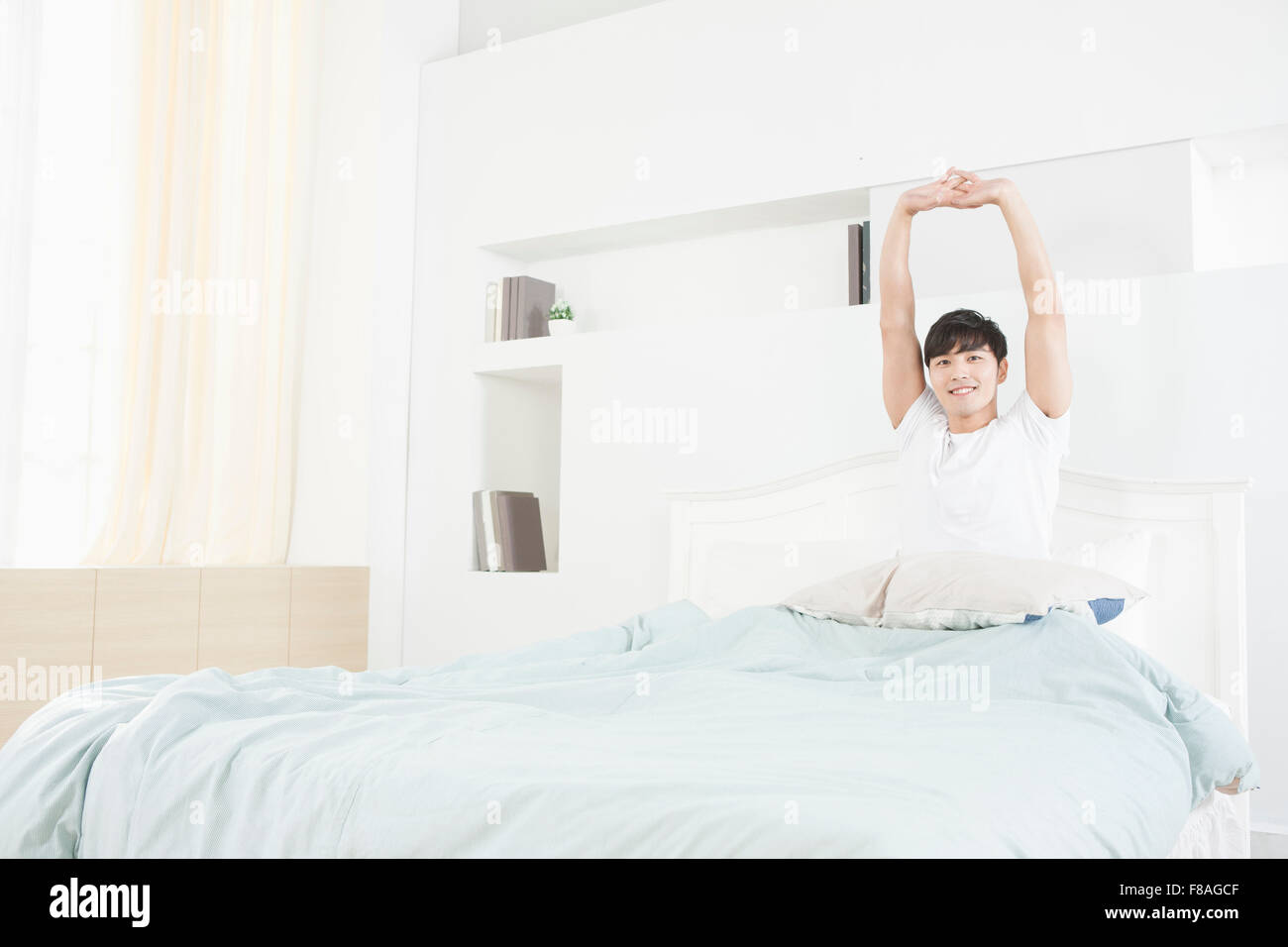 Man stretching himself in bed Stock Photo - Alamy