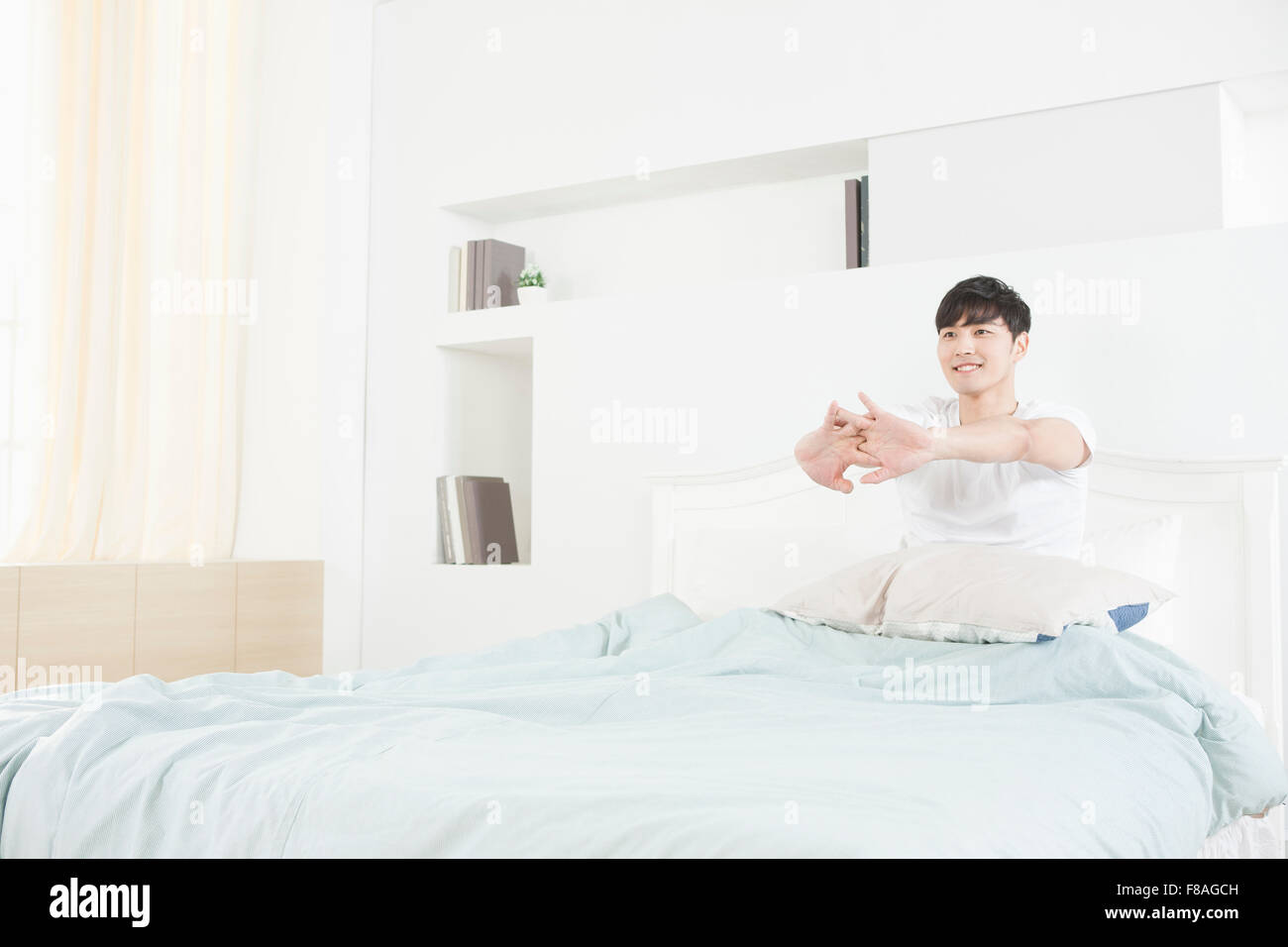 Man stretching himself in bed Stock Photo - Alamy