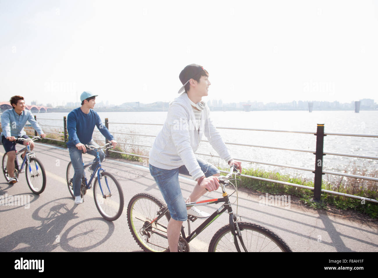Three young men riding bikes at the Hangang Park Stock Photo - Alamy