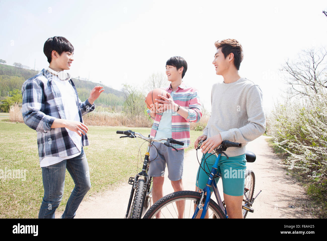 Three men looking at each other and having fun outside Stock Photo - Alamy