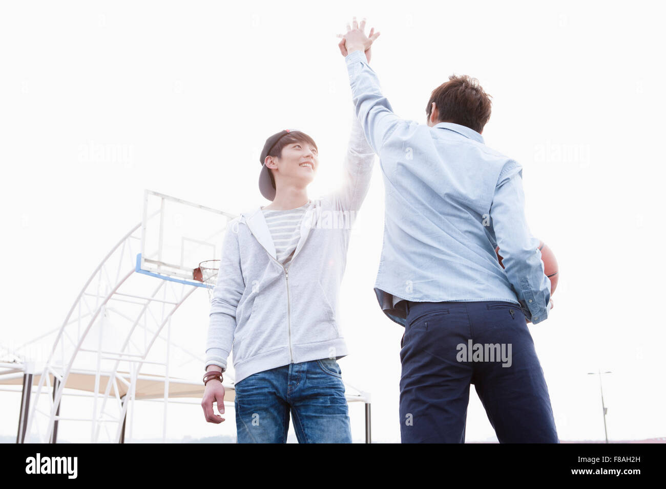 Low angle of two men giving a high-five Stock Photo - Alamy