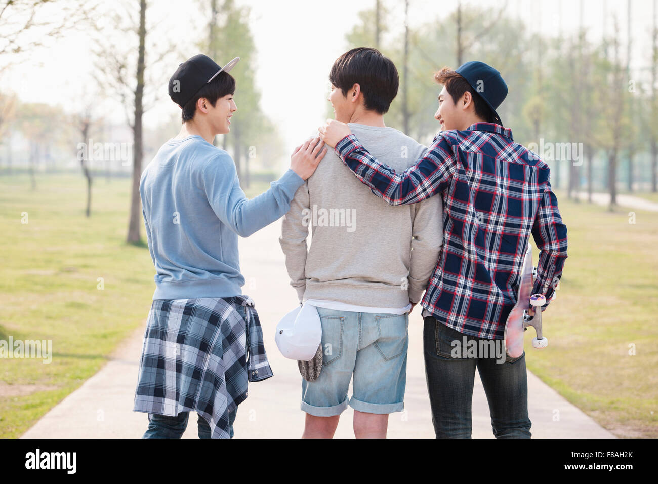 Back Appearance Of Three Men Putting Arms Around Each Others Shoulder