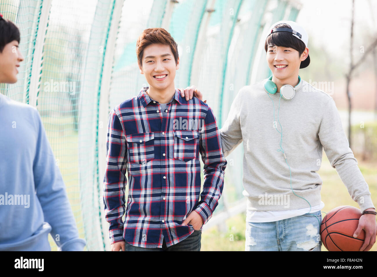 Three men hanging out together at the park Stock Photo - Alamy