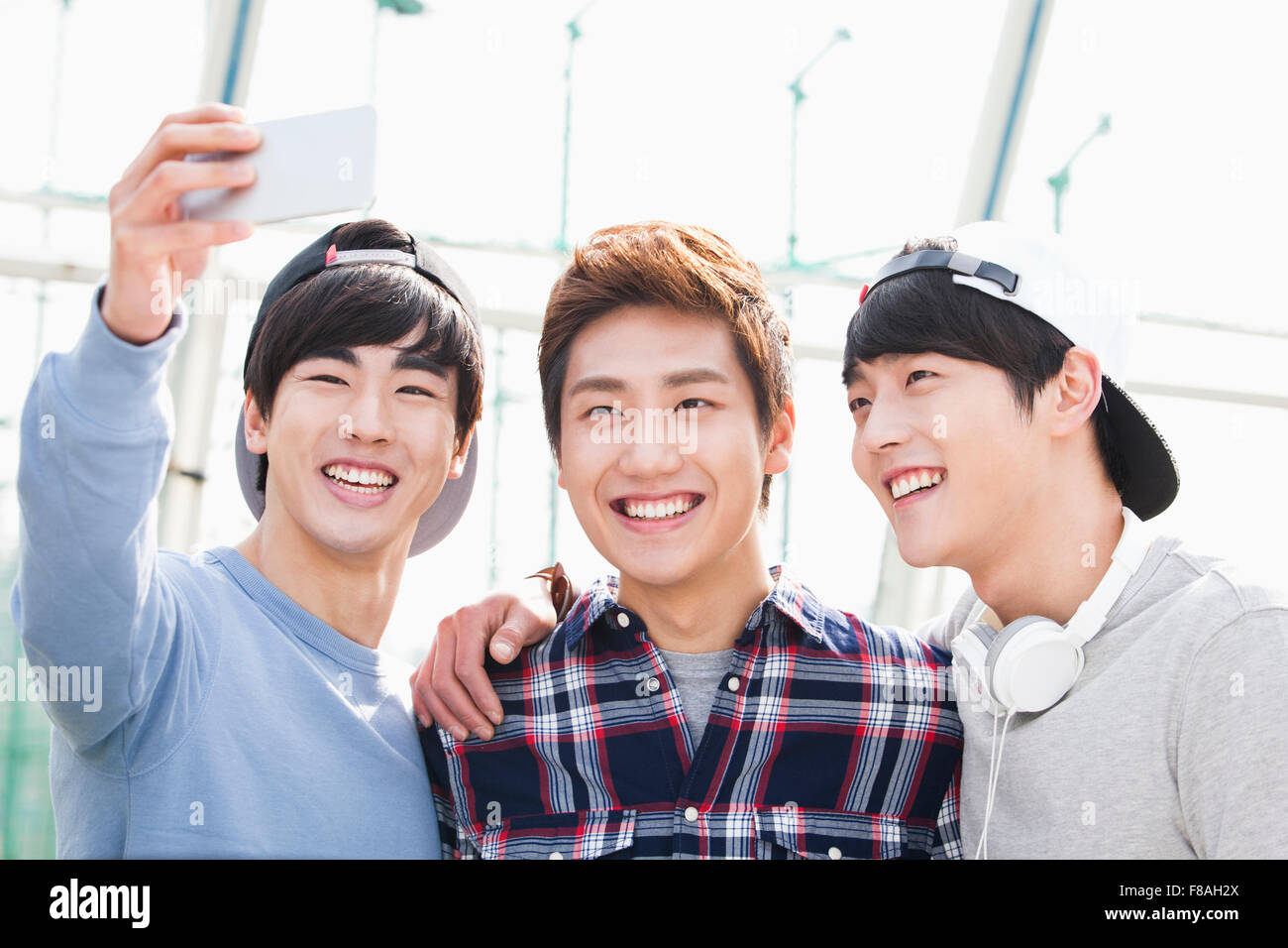 Three men taking a photo of themselves together with a phone Stock ...