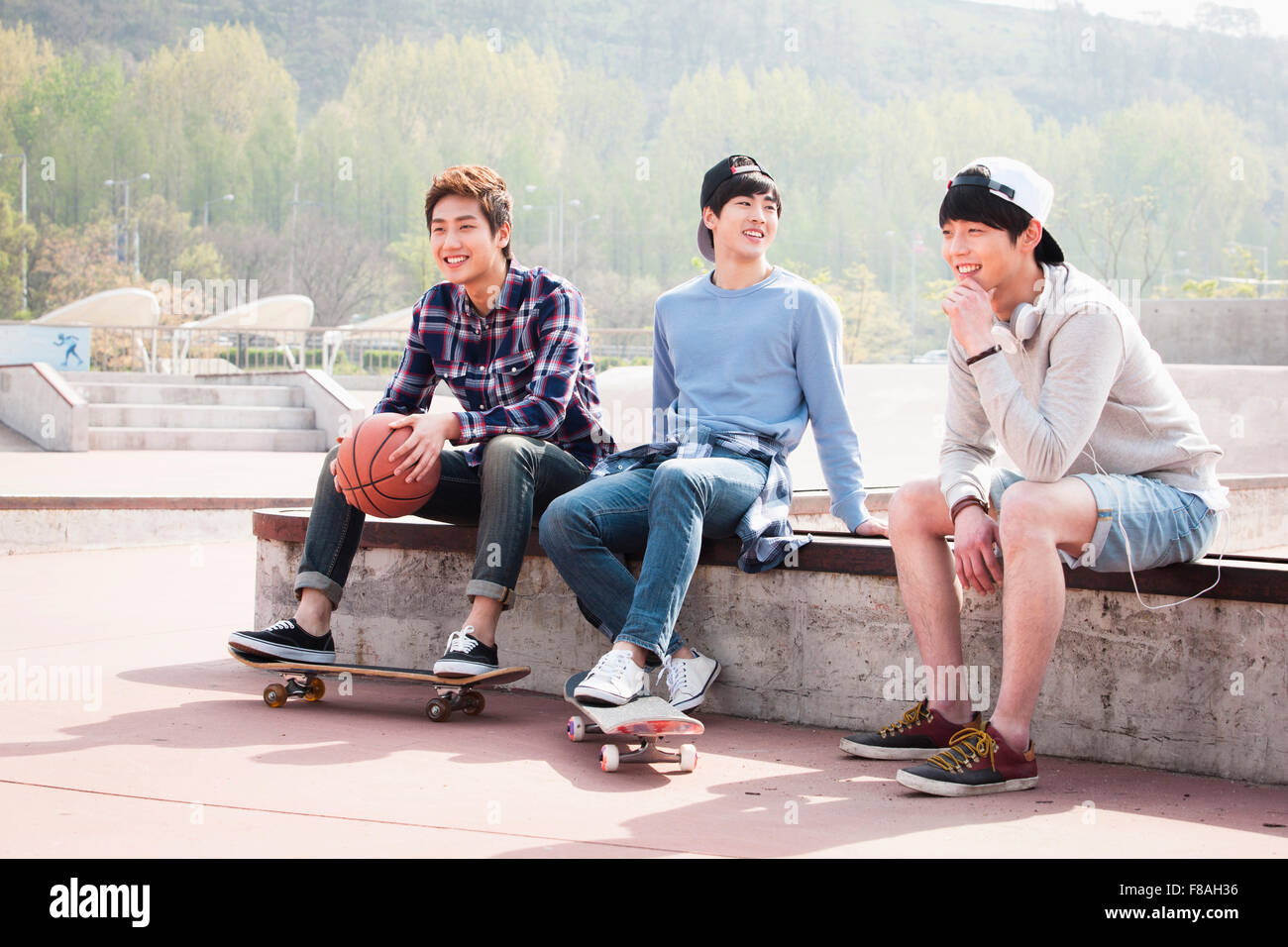 Three men sitting on the bench and relaxing together Stock Photo - Alamy
