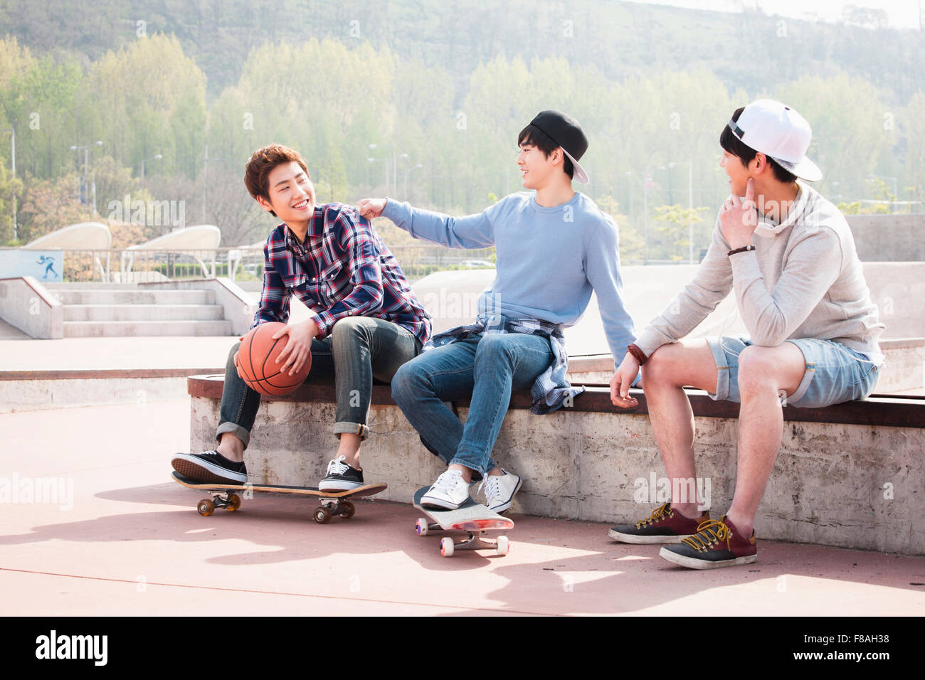 Three men sitting on the bench and relaxing together at the park Stock ...