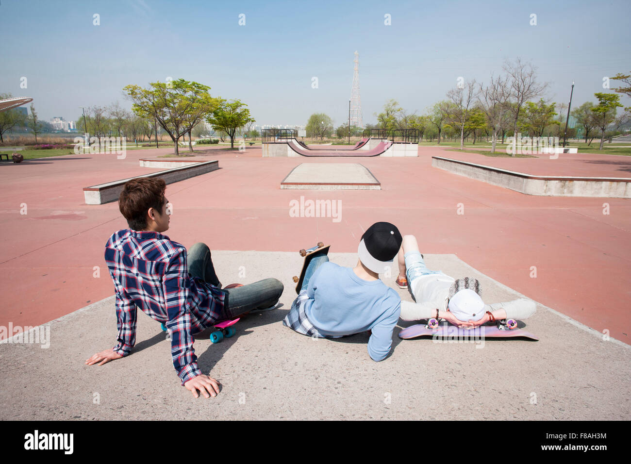 Three men relaxing at the park leaning down and lying down Stock Photo ...