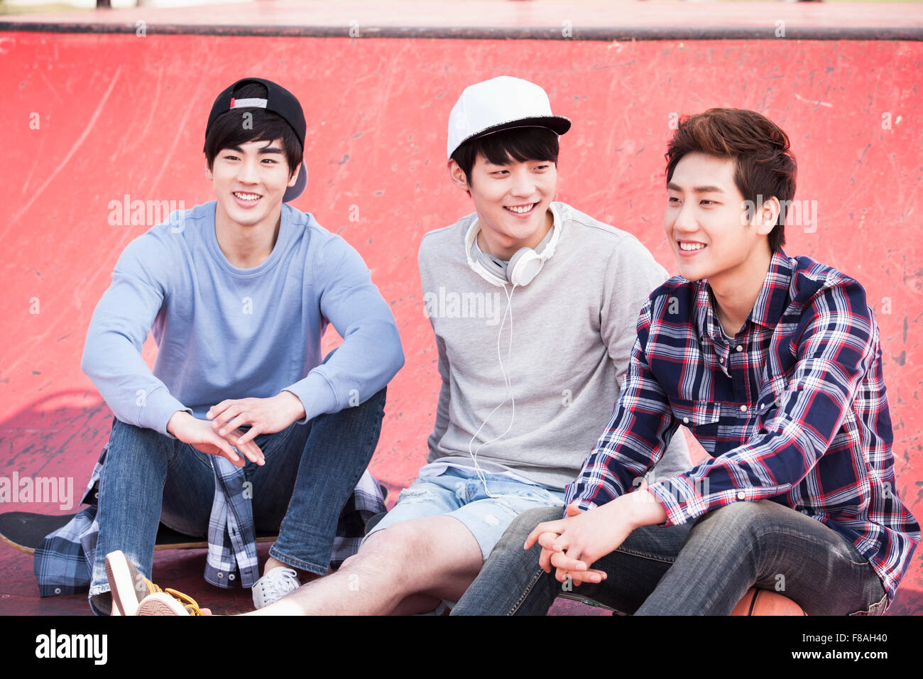Three men sitting down on the skateboard court Stock Photo - Alamy