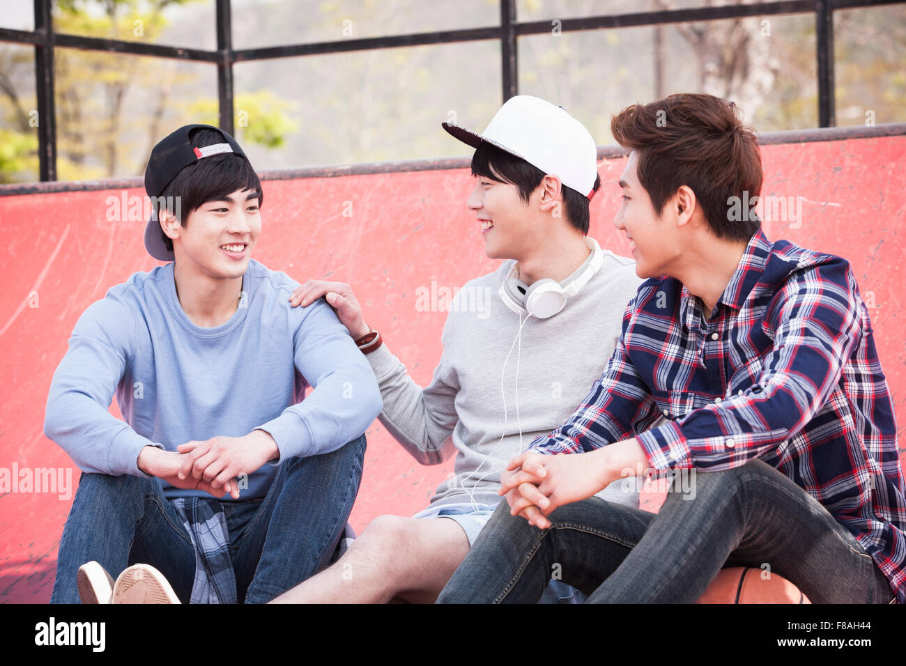 Three men sitting down on the skateboard court Stock Photo - Alamy
