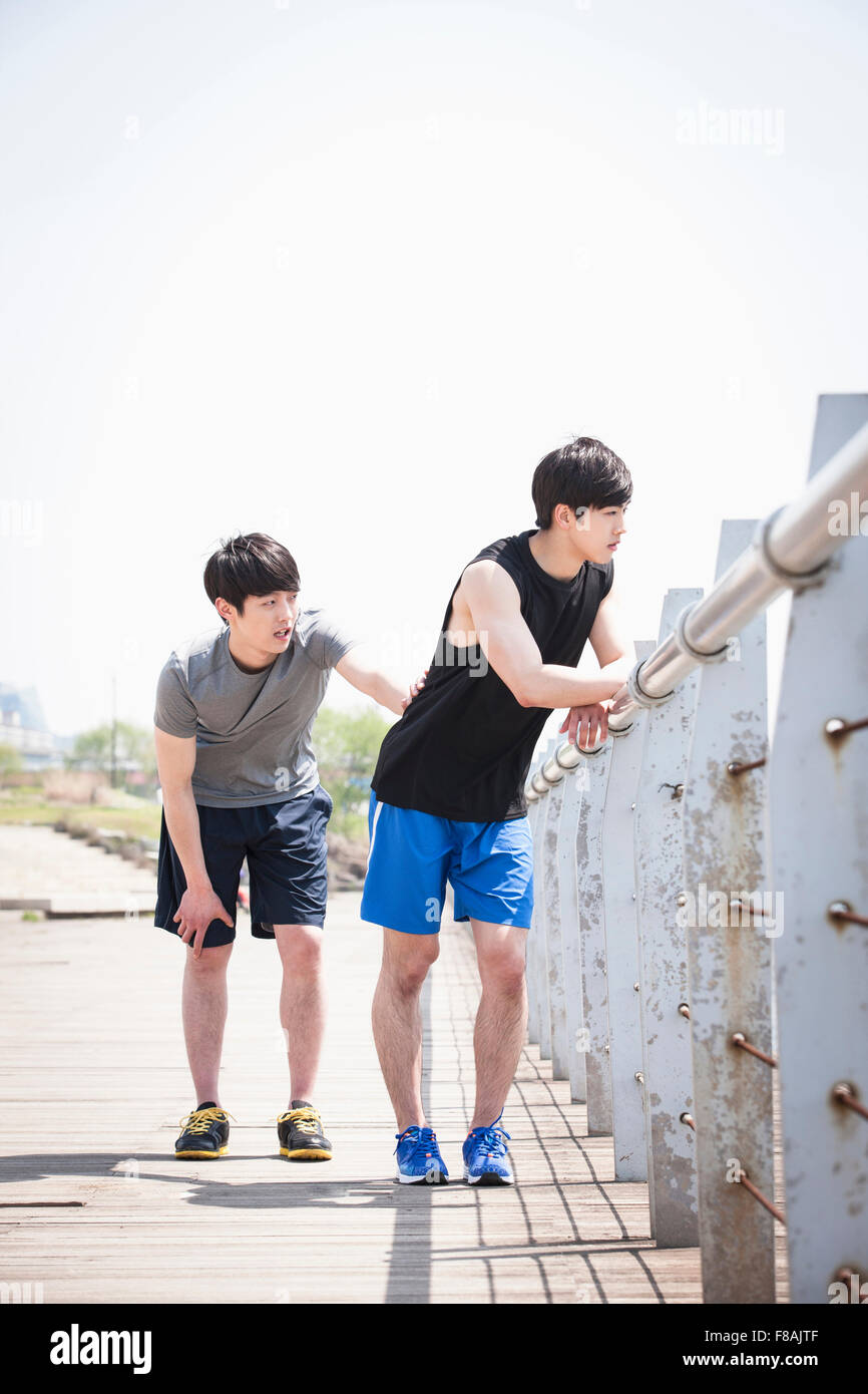 Two young men leaning on the fence at the riverside in Han river park ...