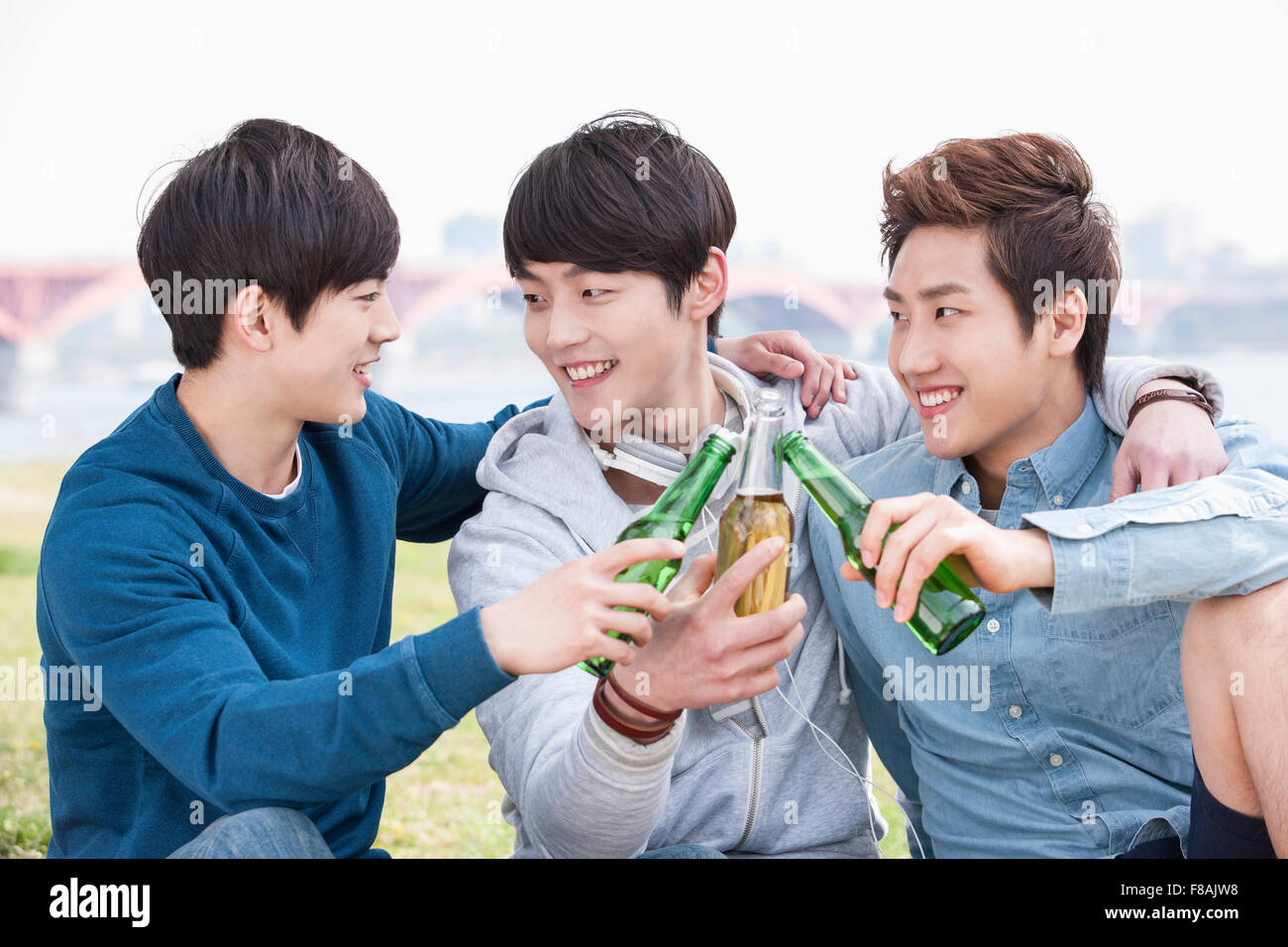 Three men sitting on grass hi-res stock photography and images - Alamy