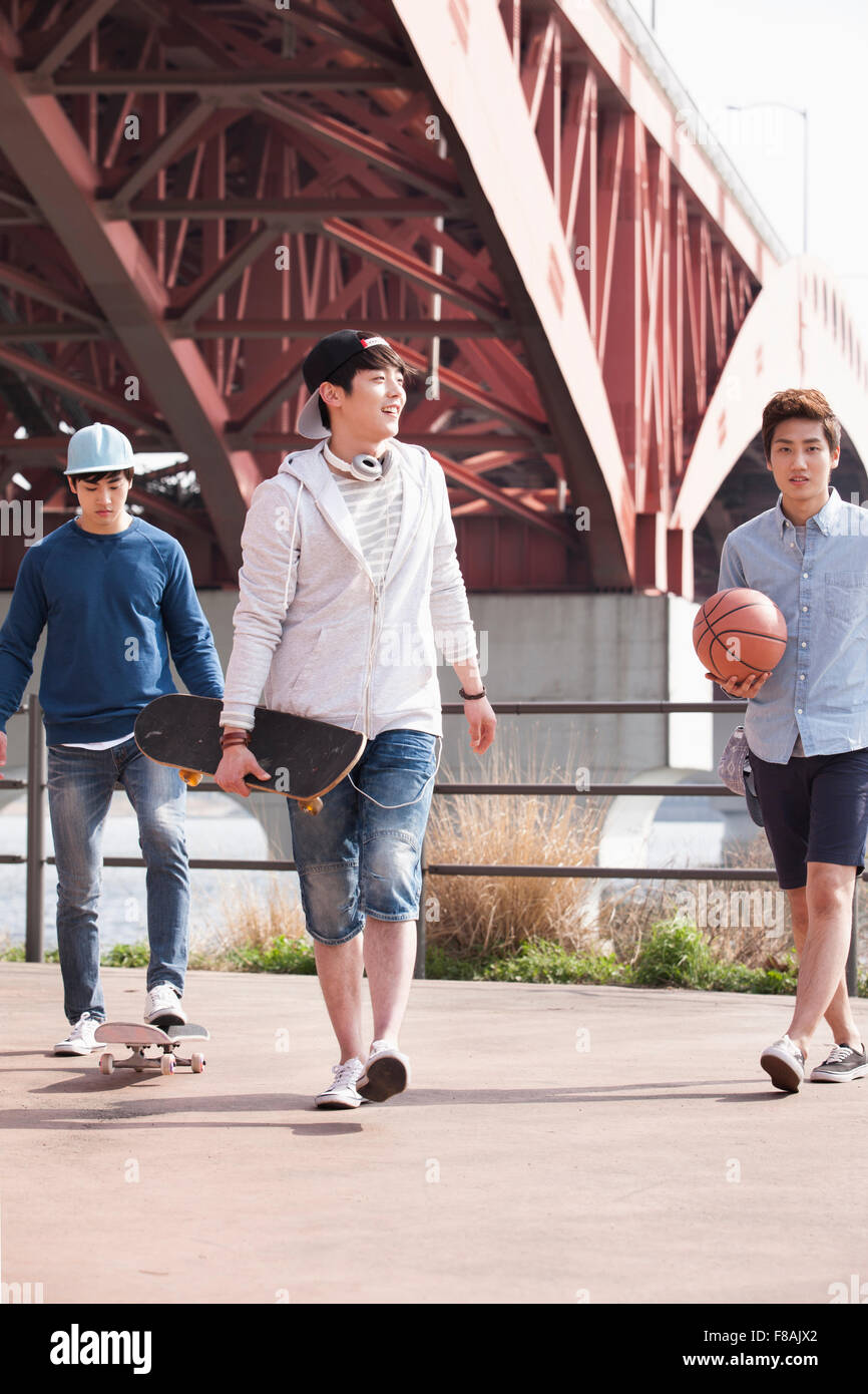 Three young men walking under the bridge at Han river park Stock Photo ...