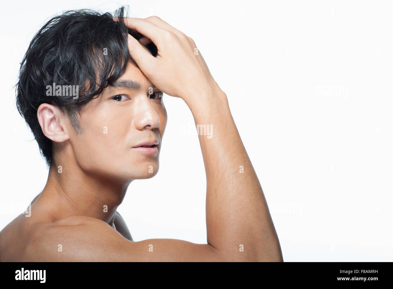 Portrait of Asian man placing his hand on head and staring at front ...