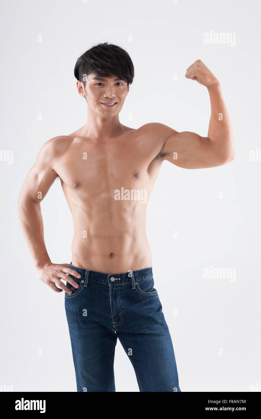Confident man showing his muscular upper body and raising arms with a ...