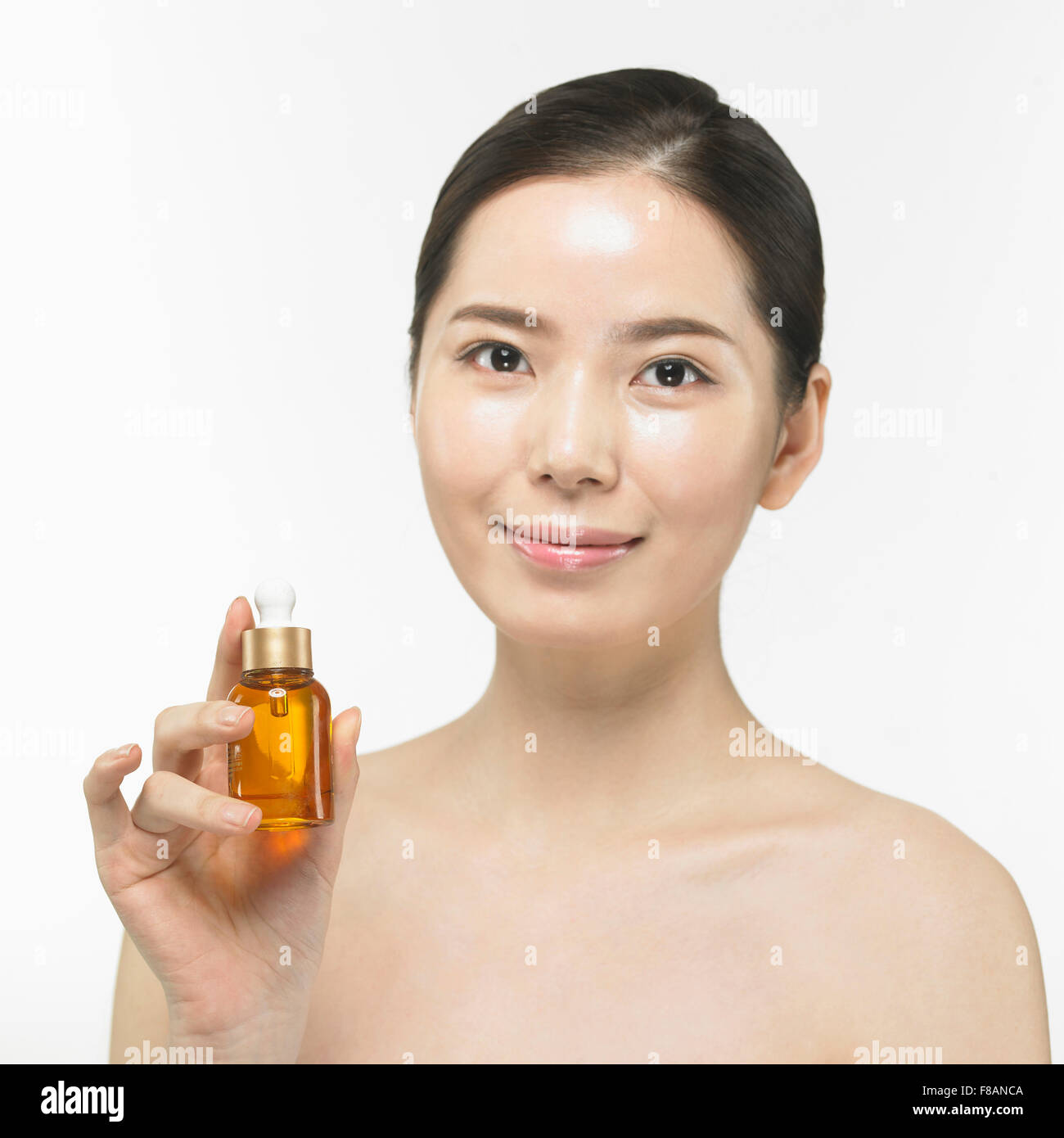 Portrait of smiling Korean woman staring at front showing cosmetic ...