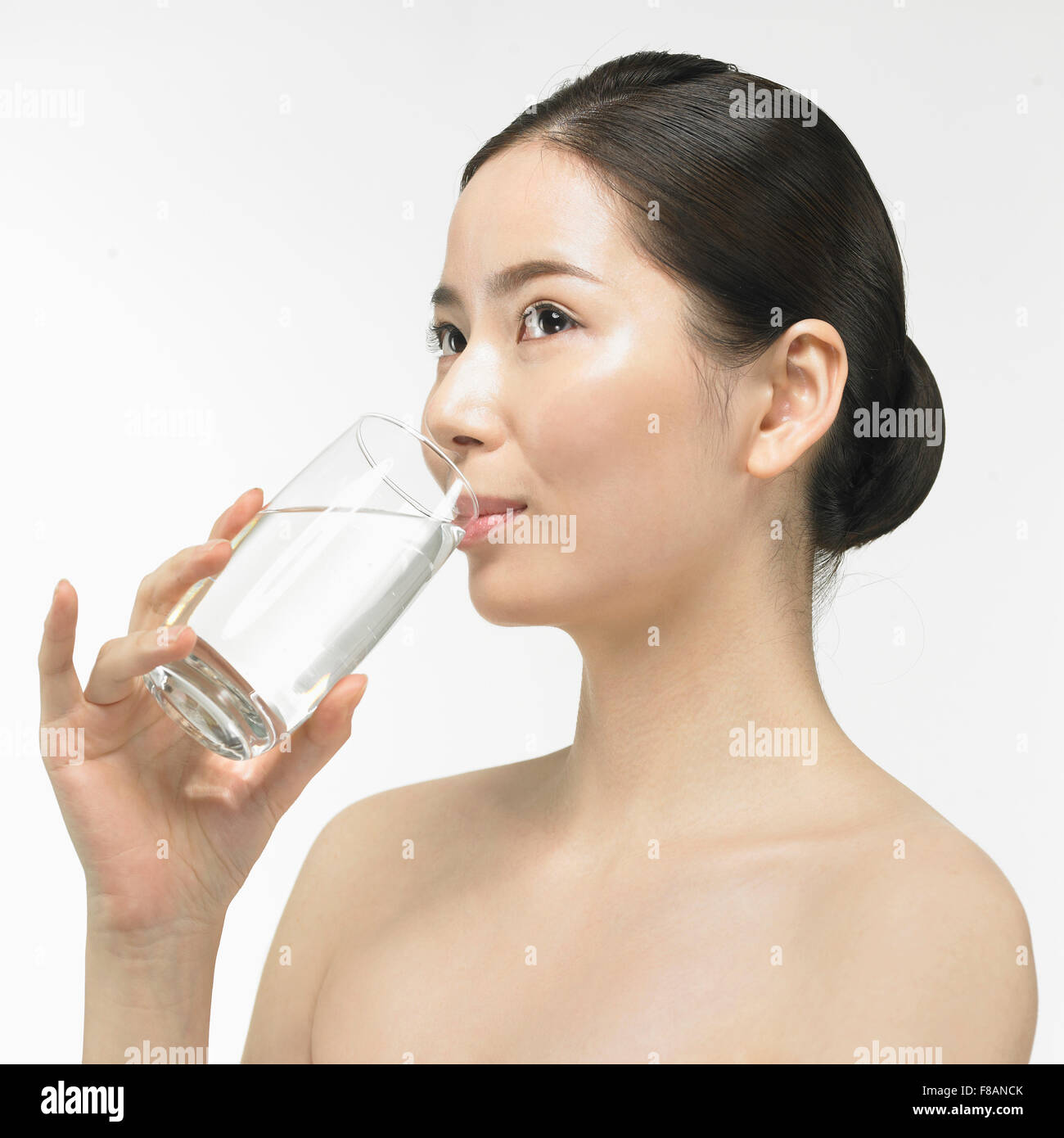 Portrait of smiling Korean woman drinking water looking up Stock Photo ...