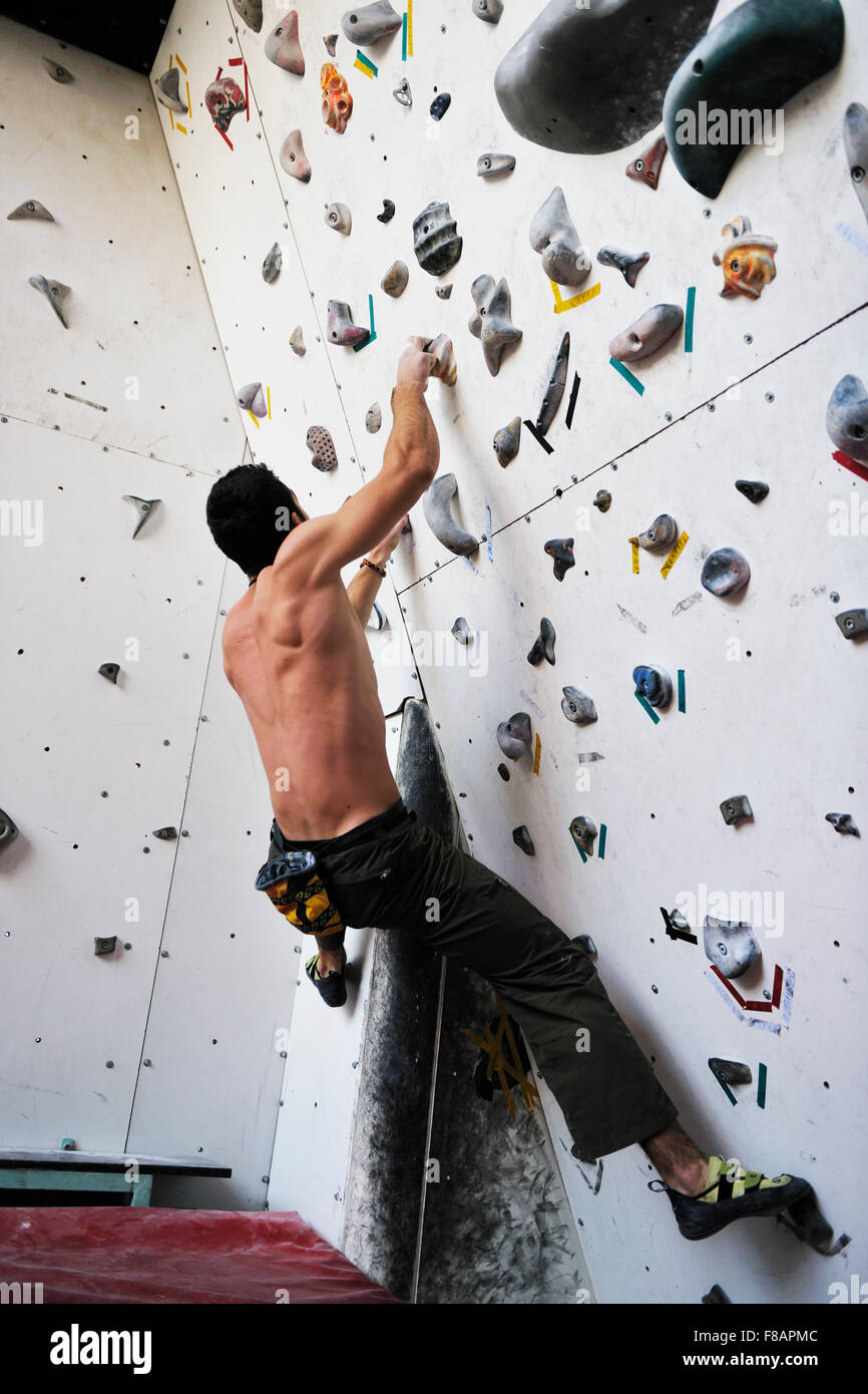 young and fit man exercise free mountain climbing on indoor practice ...