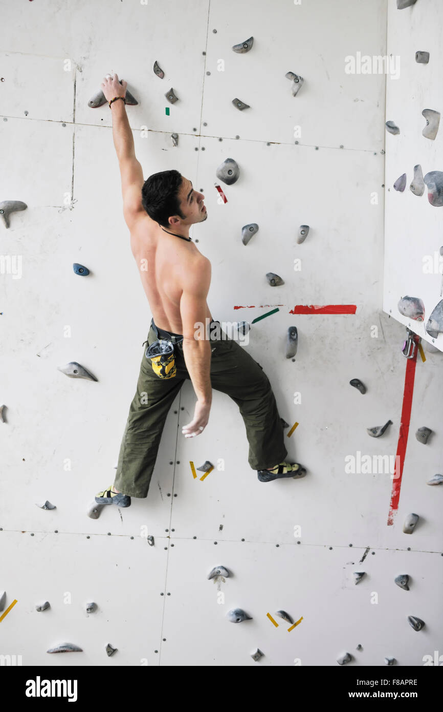 young and fit man exercise free mountain climbing on indoor practice ...
