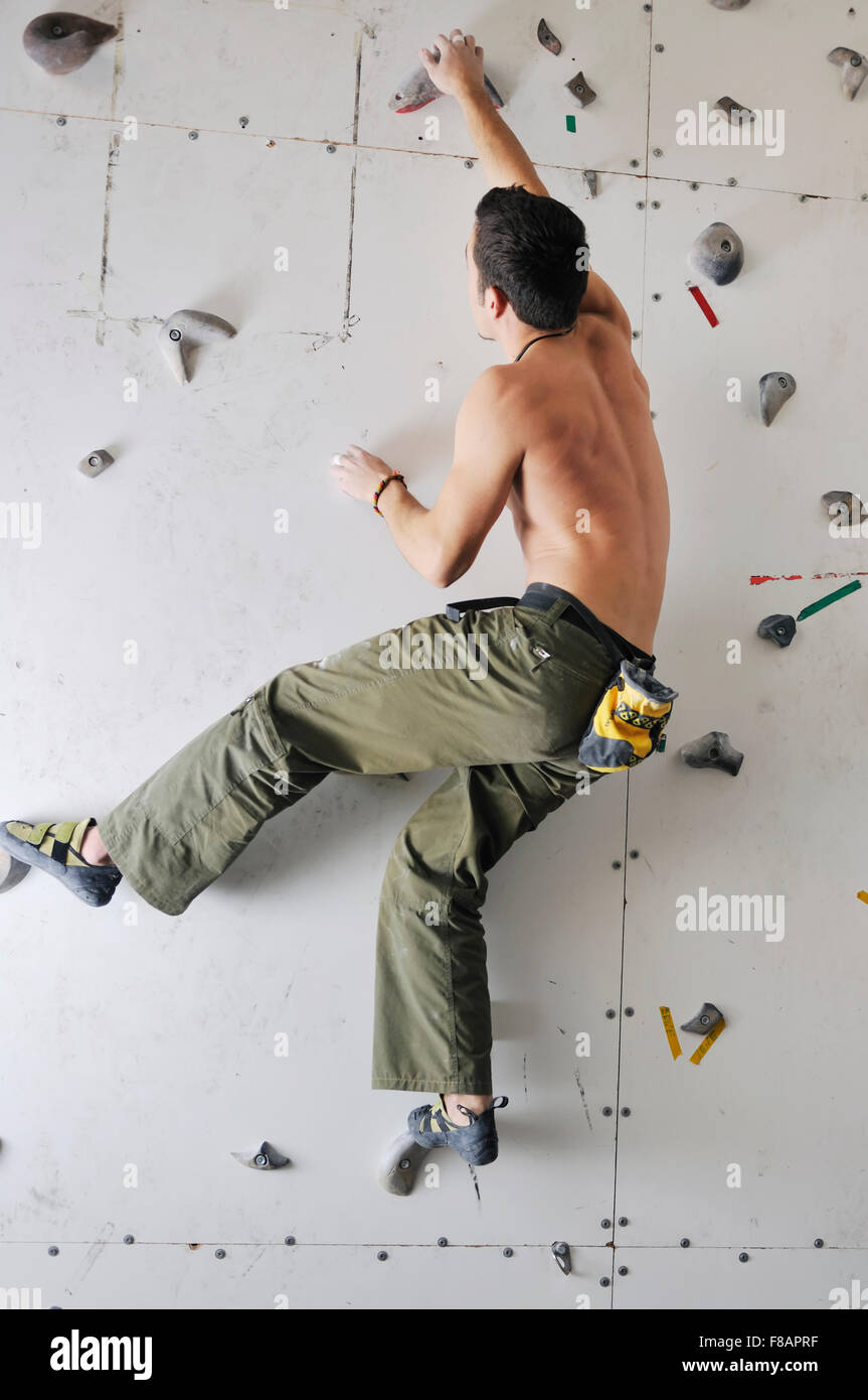 young and fit man exercise free mountain climbing on indoor practice ...