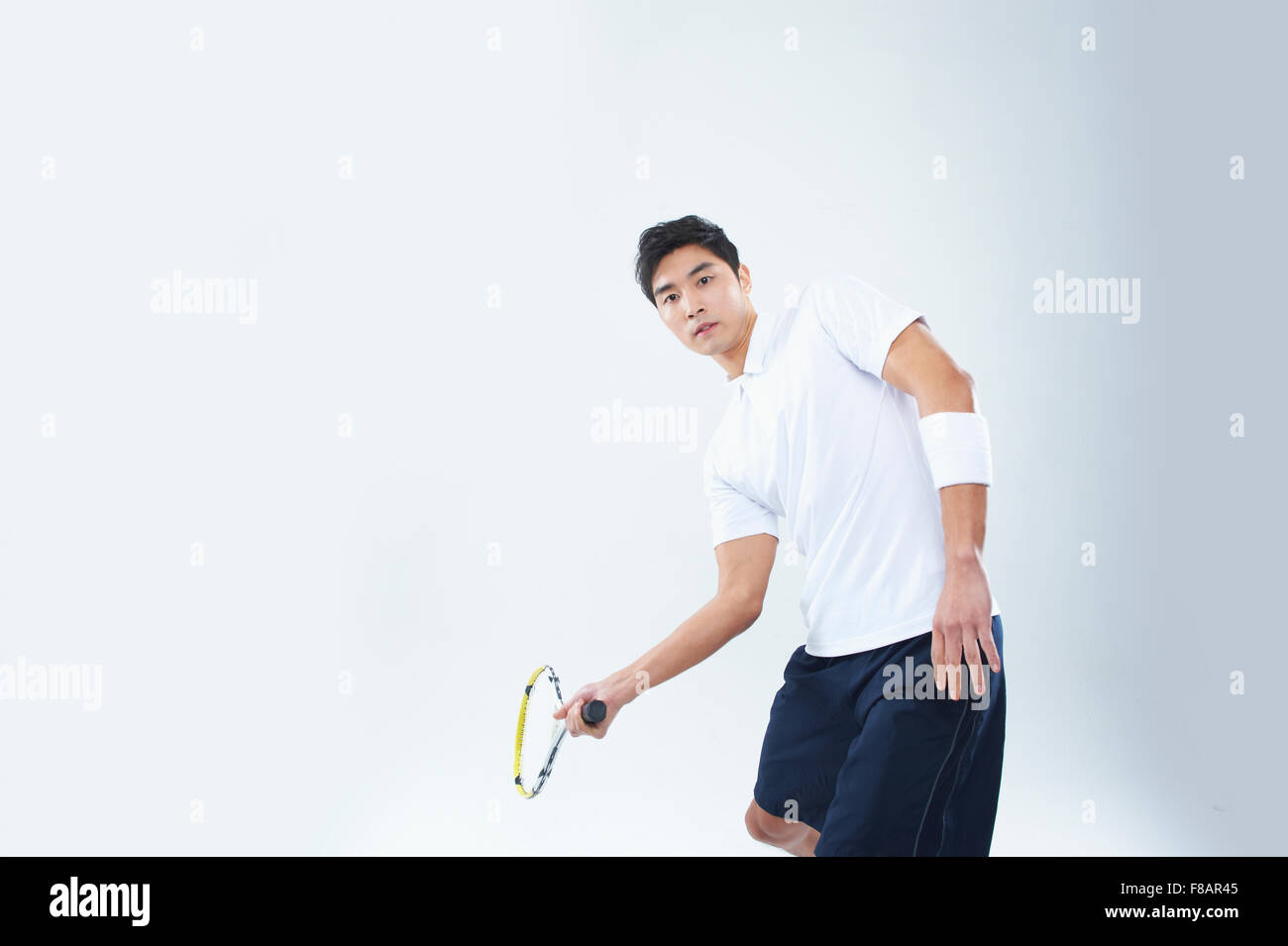 Portrait of man holding a tennis racket staring at front Stock Photo ...