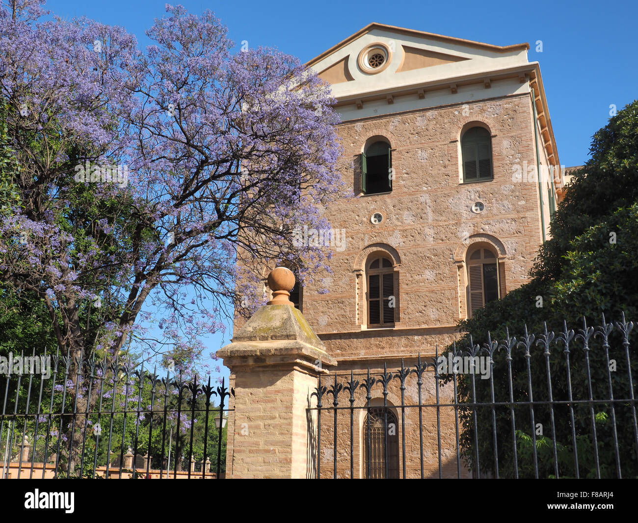 old brick house with blue flower tree Stock Photo - Alamy
