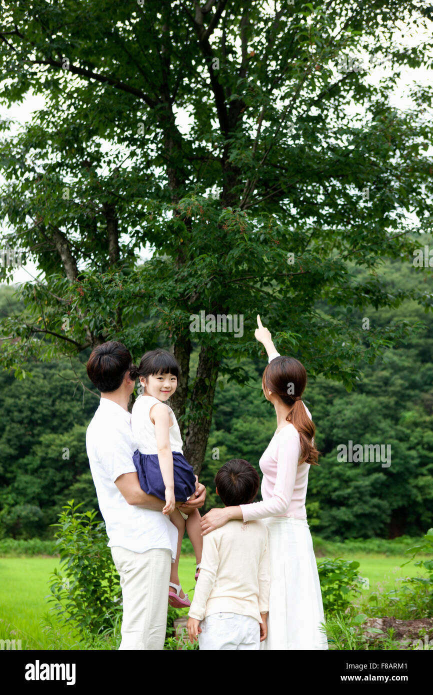 Family observing a tree in country including a girl looking back and ...