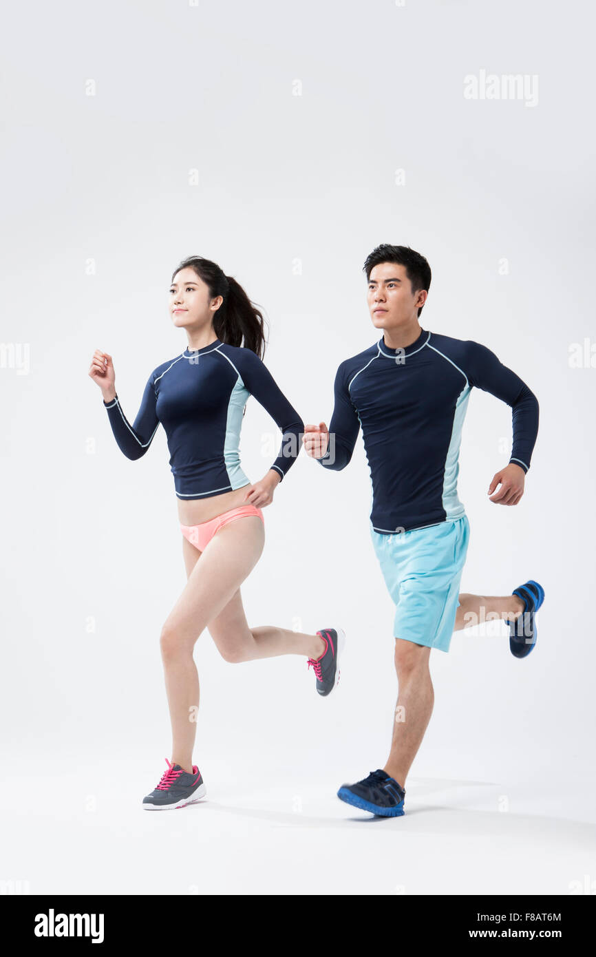 Couple in sportswears running looking up Stock Photo - Alamy