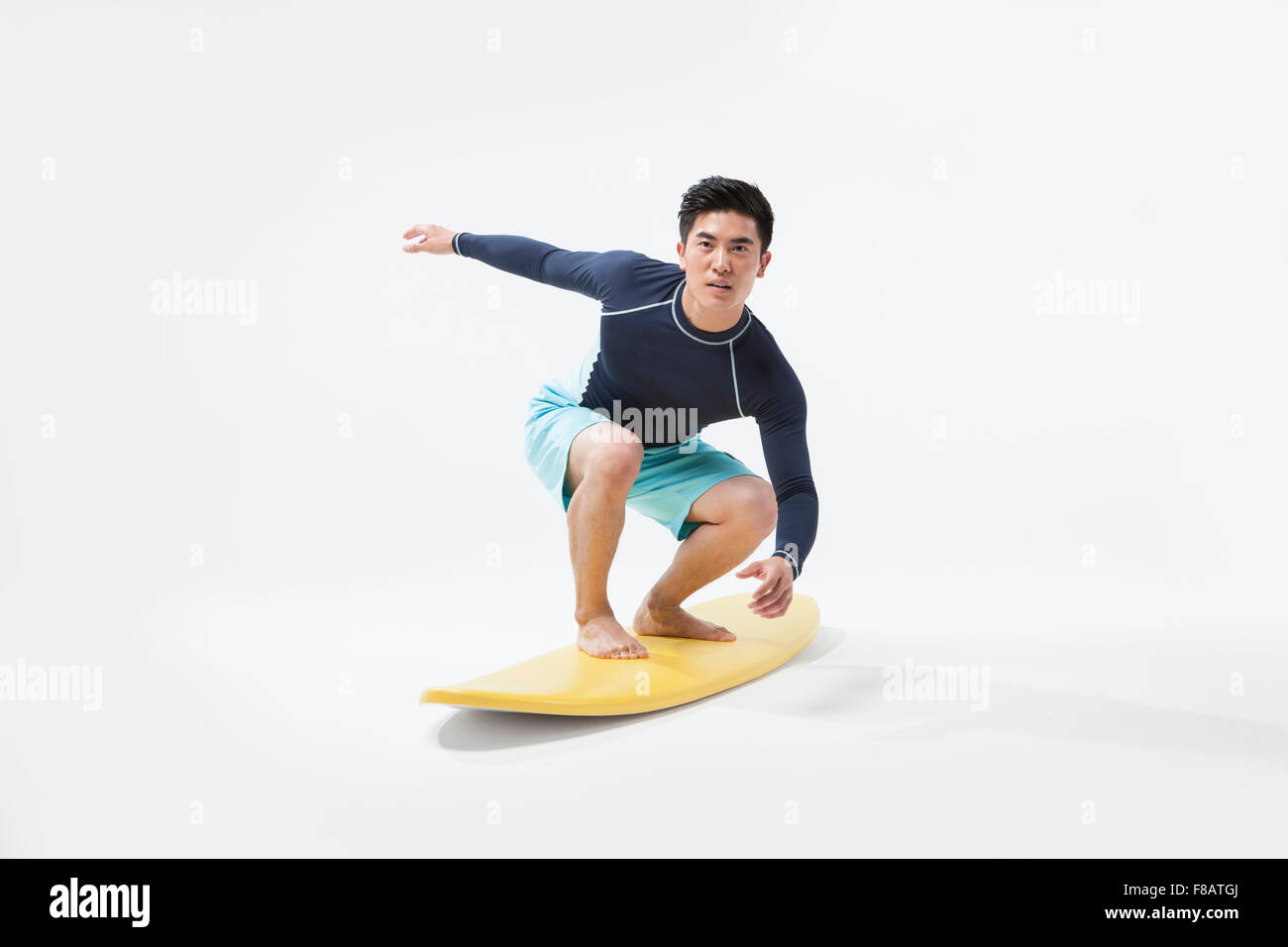 Man balancing on a surfing board staring at front Stock Photo - Alamy