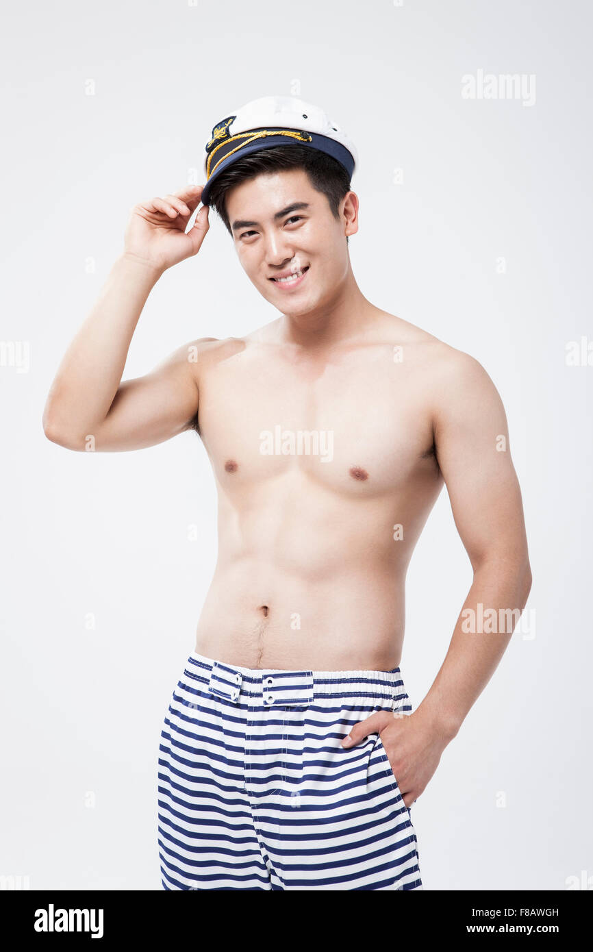 Young man wearing a captain cap and swimsuit with a smile Stock Photo ...