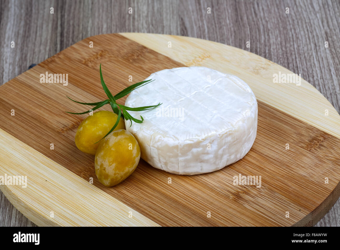 Round Brie cheese with yellow plums and estragon Stock Photo - Alamy