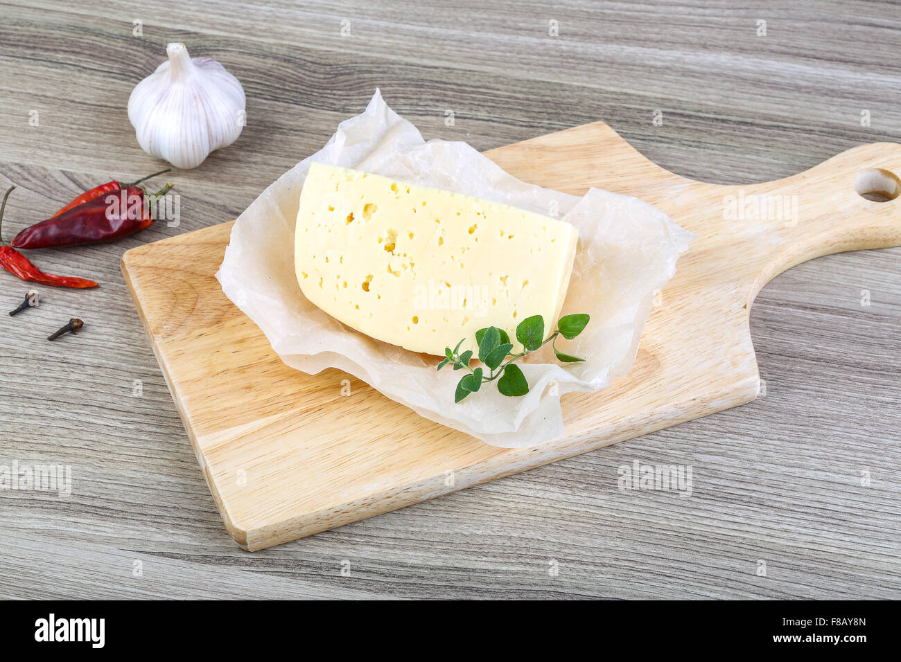 Part of round cheese on the wood background with herbs Stock Photo - Alamy
