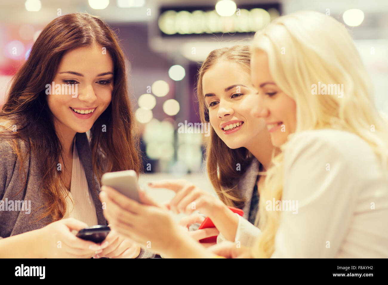 happy women with smartphones and tablet pc in mall Stock Photo - Alamy