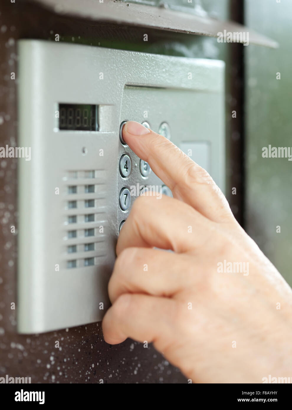 Close-up of person using building intercom Stock Photo - Alamy