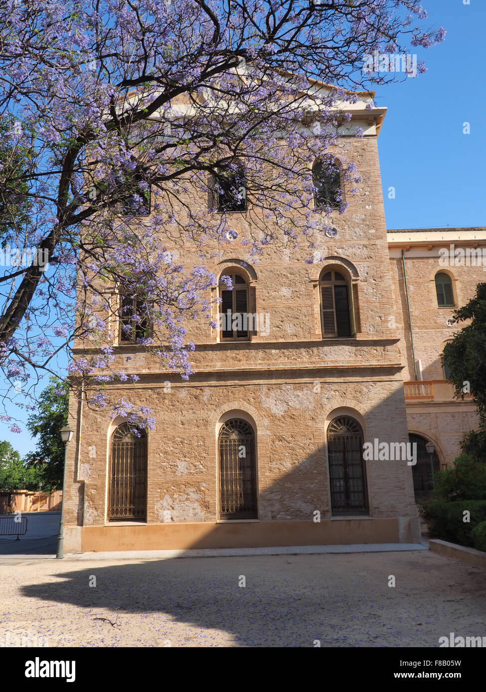 old brick house with blue flower tree Stock Photo - Alamy