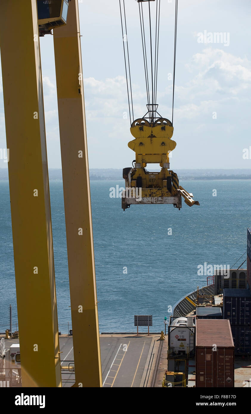 The container is lifted and transported by crane over the dock at the ...