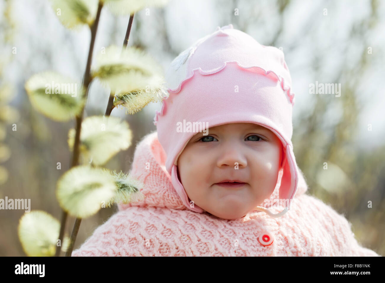 Seven months baby girl against spring Willow branches with buds Stock ...