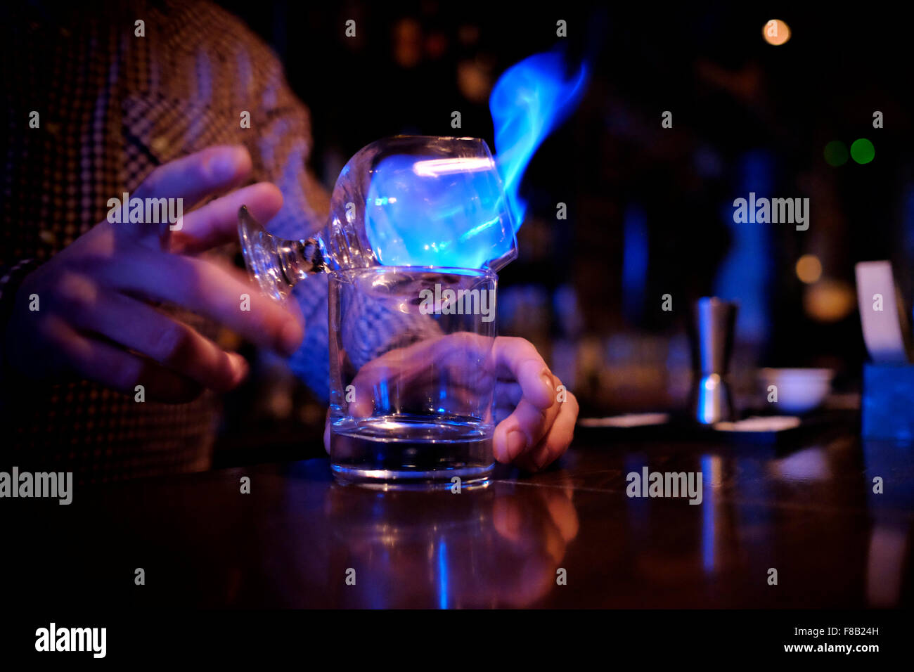 A barman making a flaming cocktail in a bar Stock Photo - Alamy