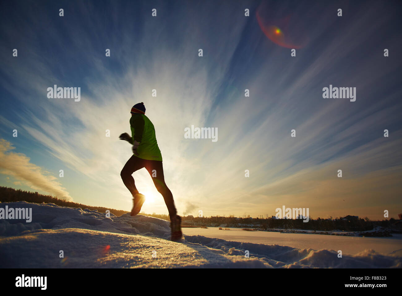 Young sportsman running in snow in rural environment Stock Photo - Alamy