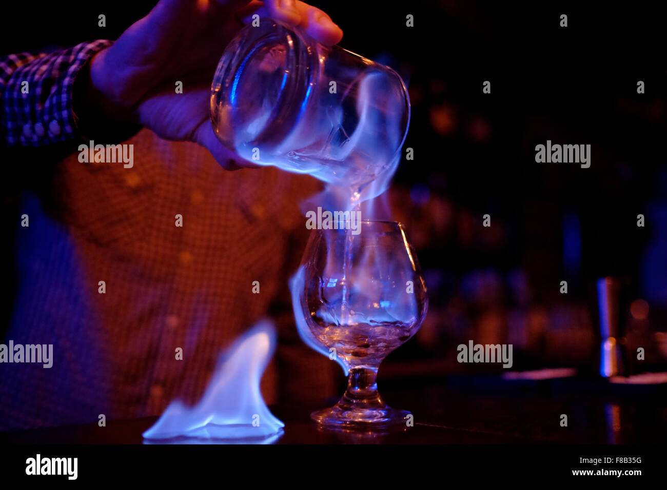 A barman makes a flaming cocktail in a bar Stock Photo - Alamy
