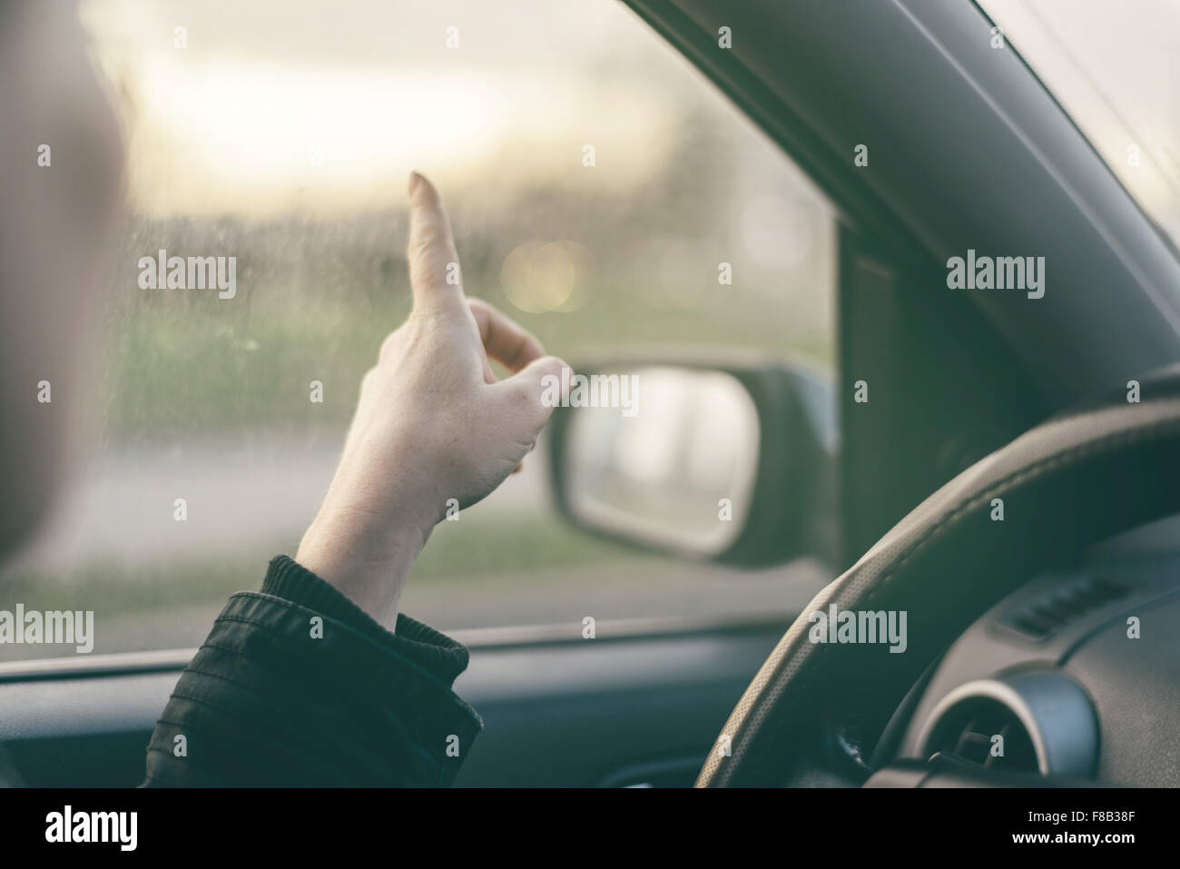 Female driver finger pointing direction, woman driving a car, retro ...